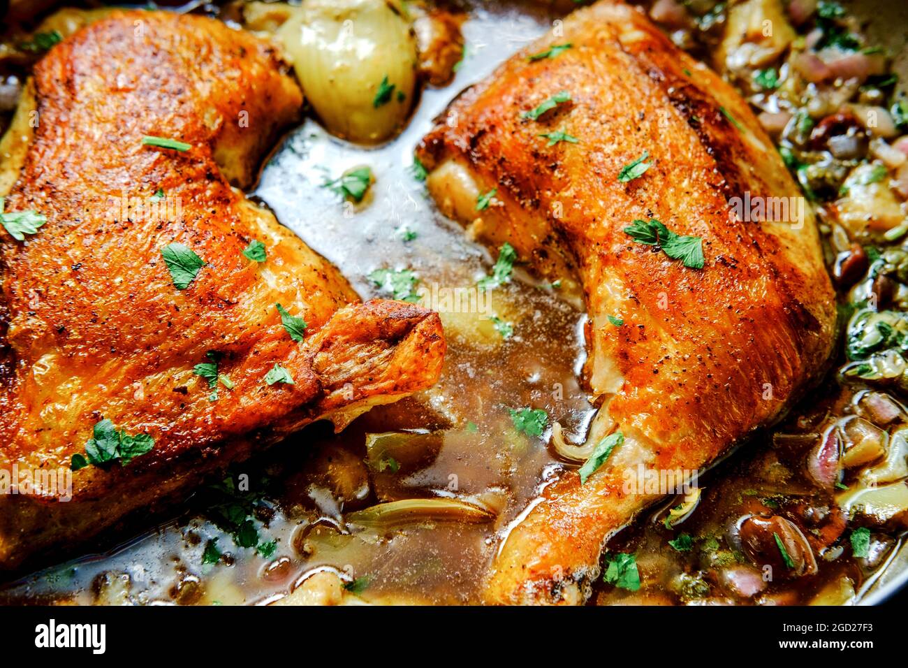 Cooking Italian split chicken leg piccata in large pan on kitchen stove ...