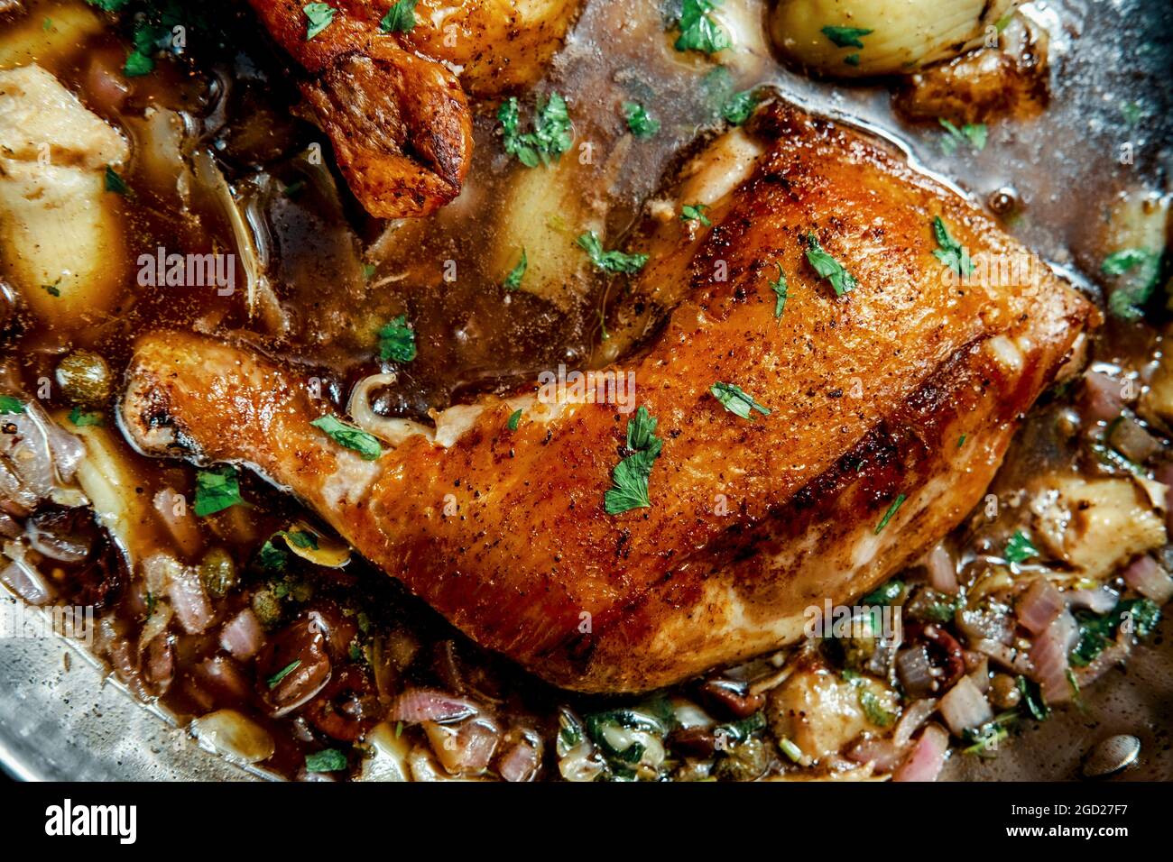 Cooking Italian split chicken leg piccata in large pan on kitchen stove ...