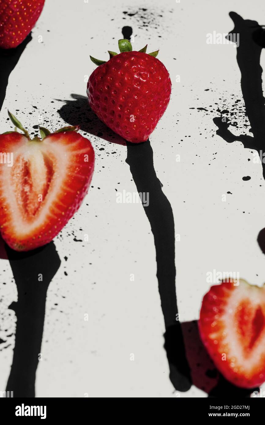 Fresh strawberries on abstract black and white paint drip background ...