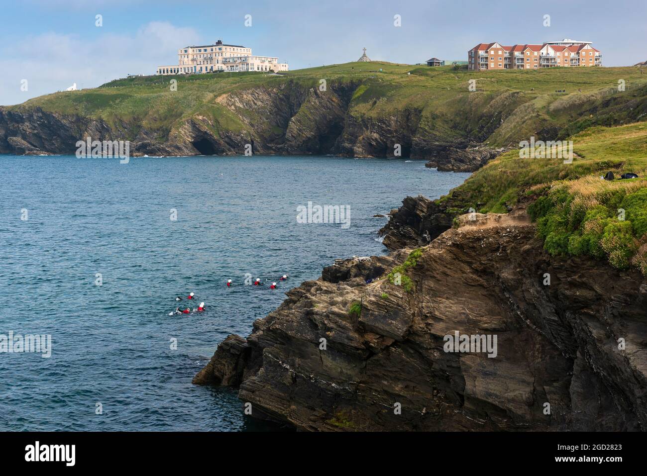 Holidaymakers swimming in the sea as part of a coasteering adventure ...