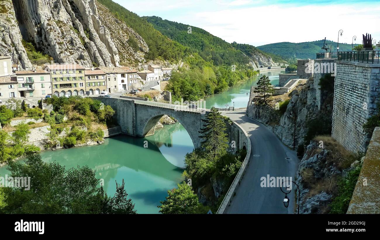 View on river durance with old bridge and village at food of mountain ...