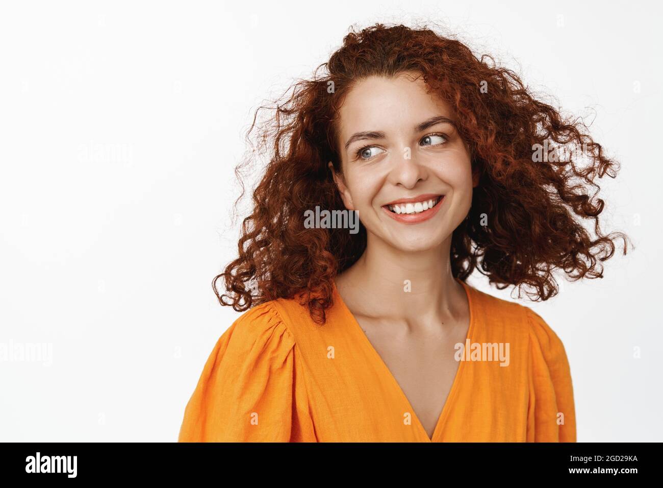 Beauty and skin care. Attractive redhead woman with curly hair flying ...