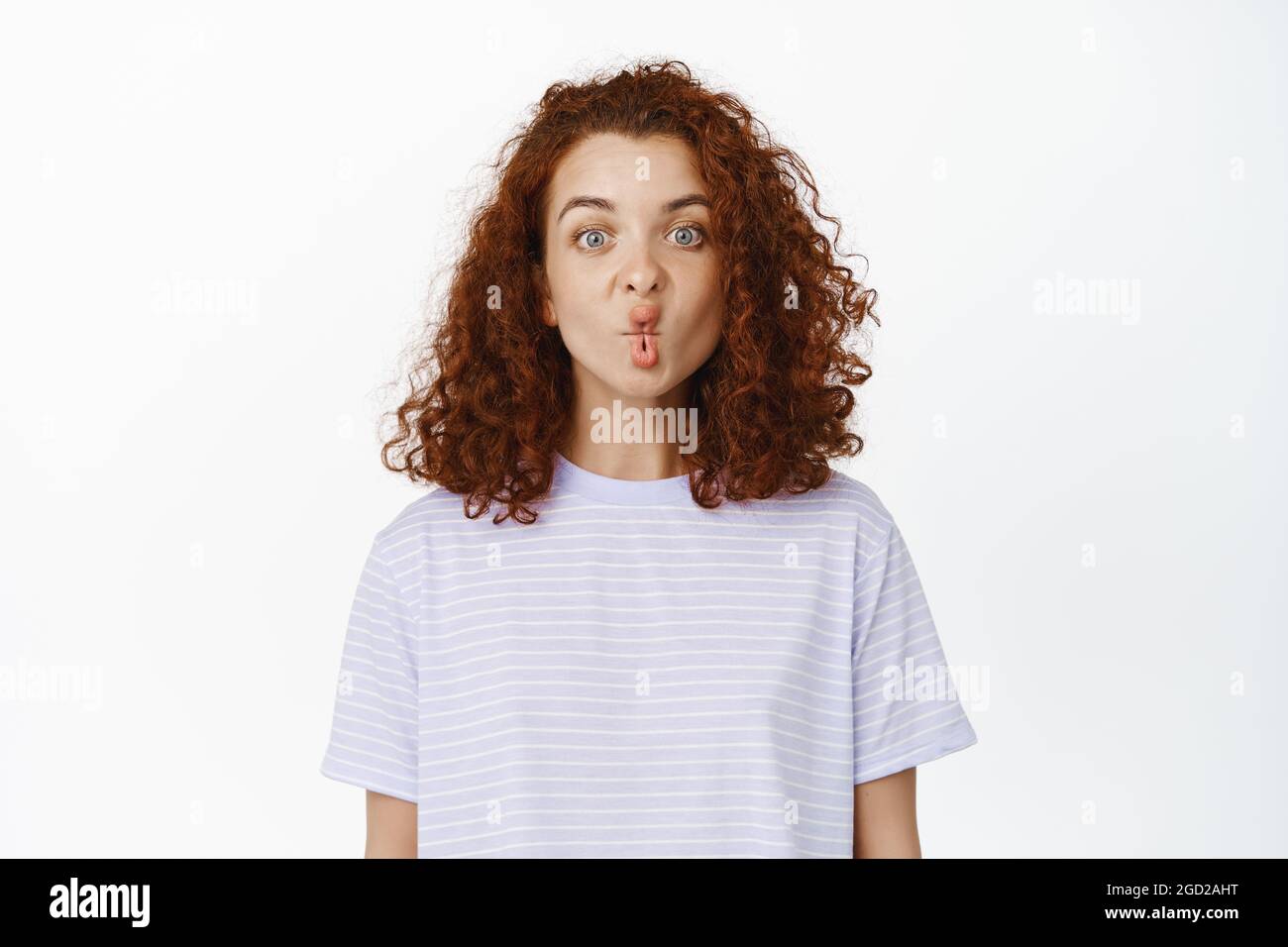 Image of silly young woman with red curly hair, pucker lips, showing ...