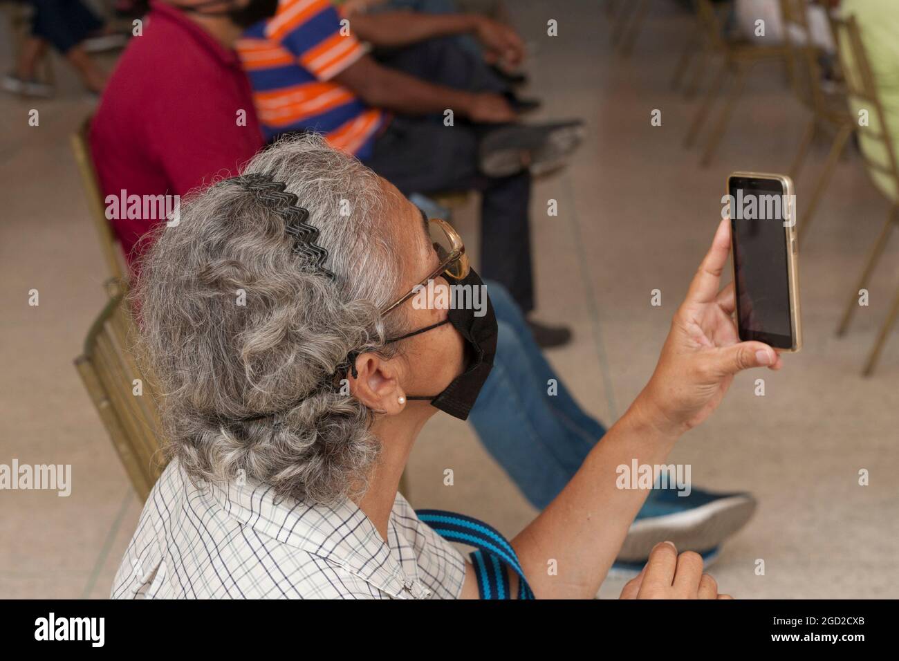 Maracaibo-Venezuela-27-07-2021- A old lady look the screen of her cell ...