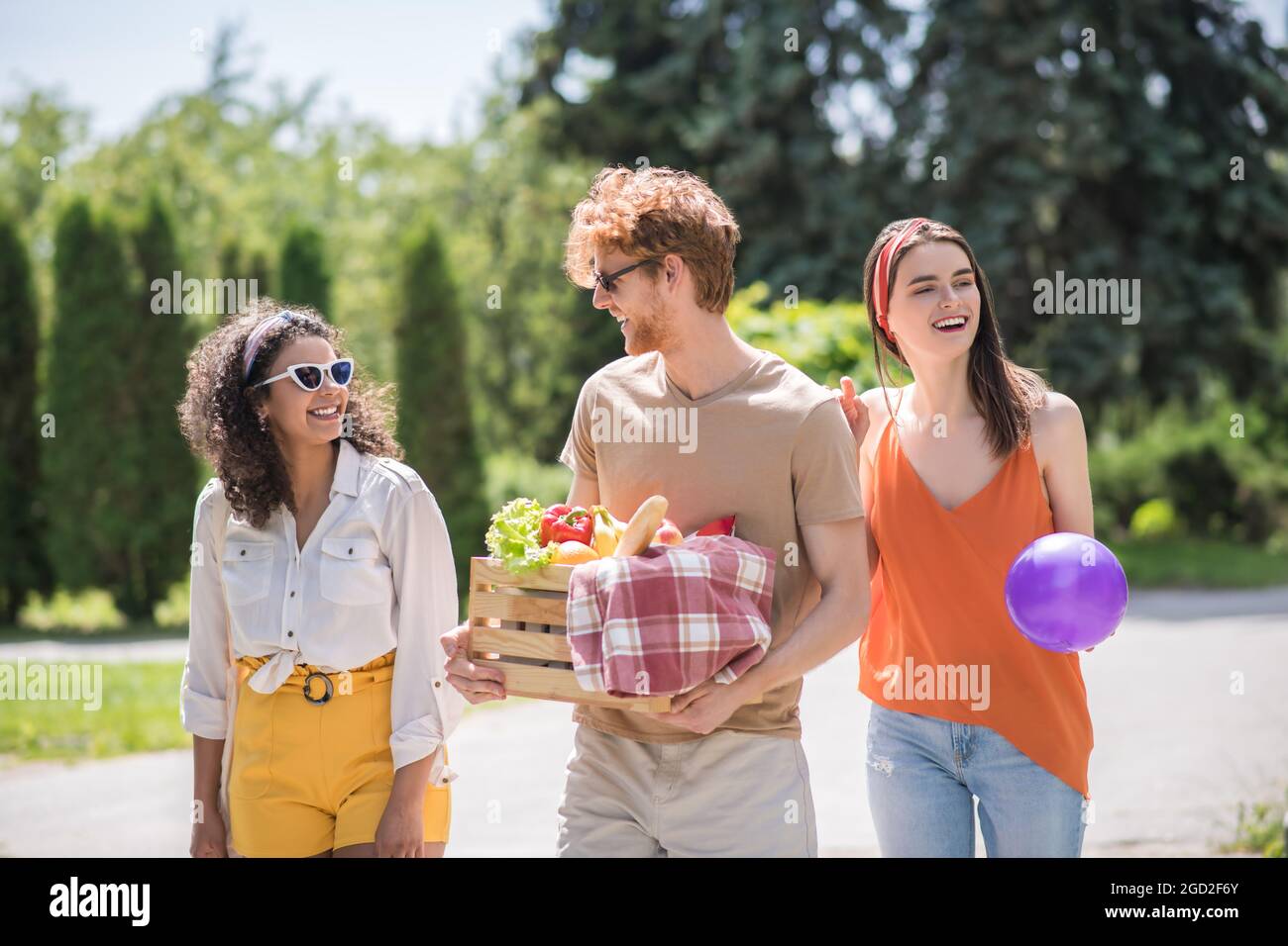 Three young people going on summer picnic Stock Photo - Alamy