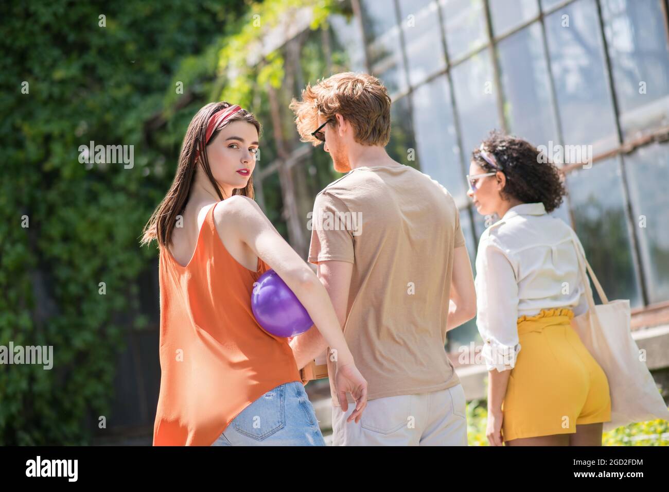 Back view of three young people walking in park Stock Photo - Alamy