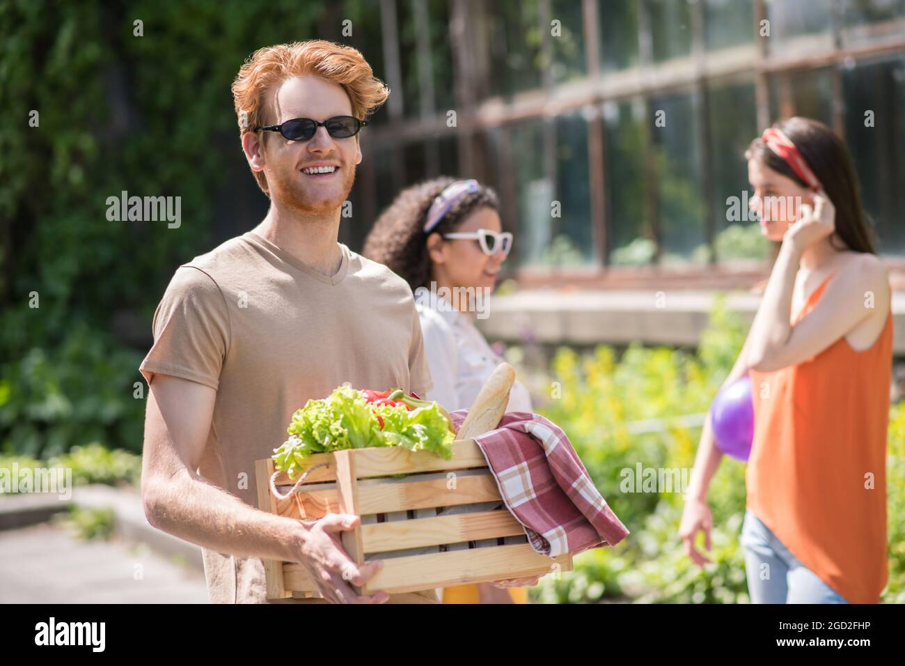 Guy with box of food and girlfriend behind Stock Photo - Alamy