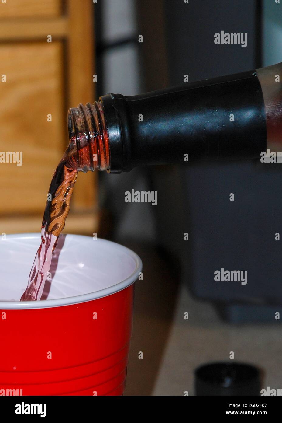 Alcohol from the bottle being poured into a red solo cup Stock Photo ...