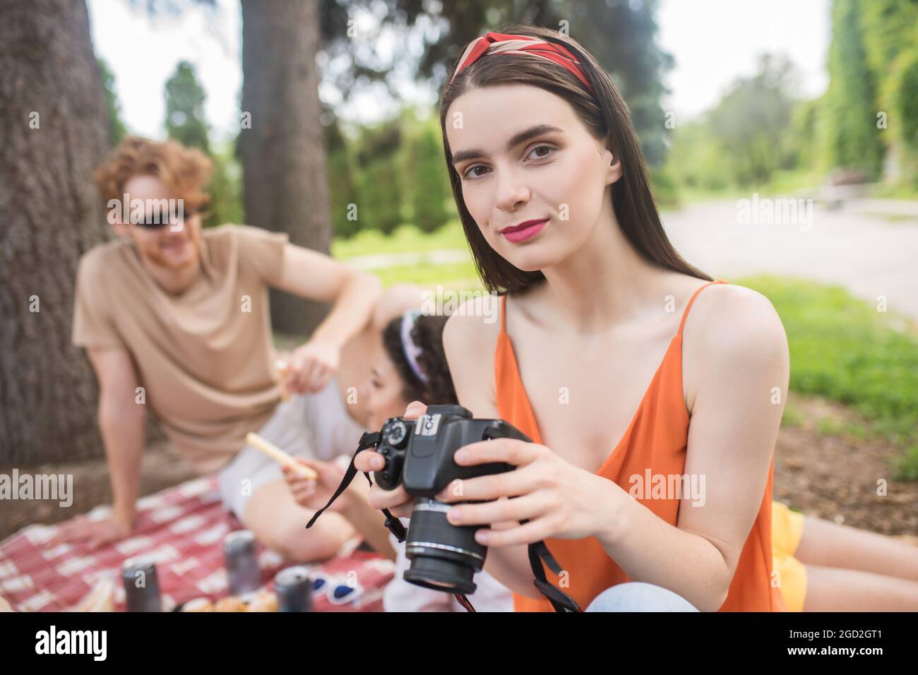Cute girl with camera and friends behind Stock Photo - Alamy