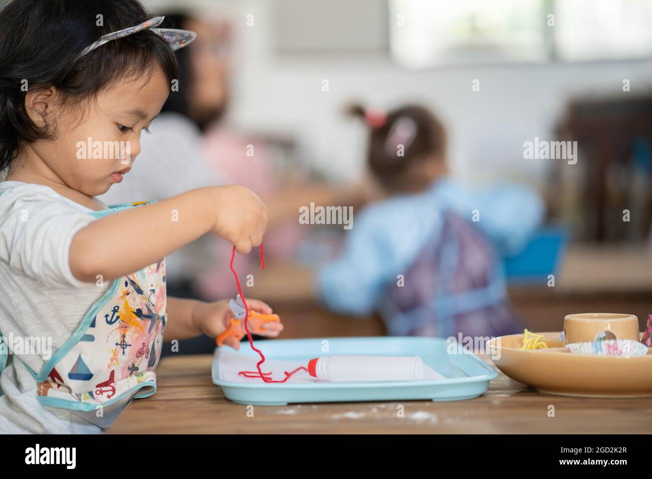 Small Asian female child playing with string at preschool Stock Photo ...