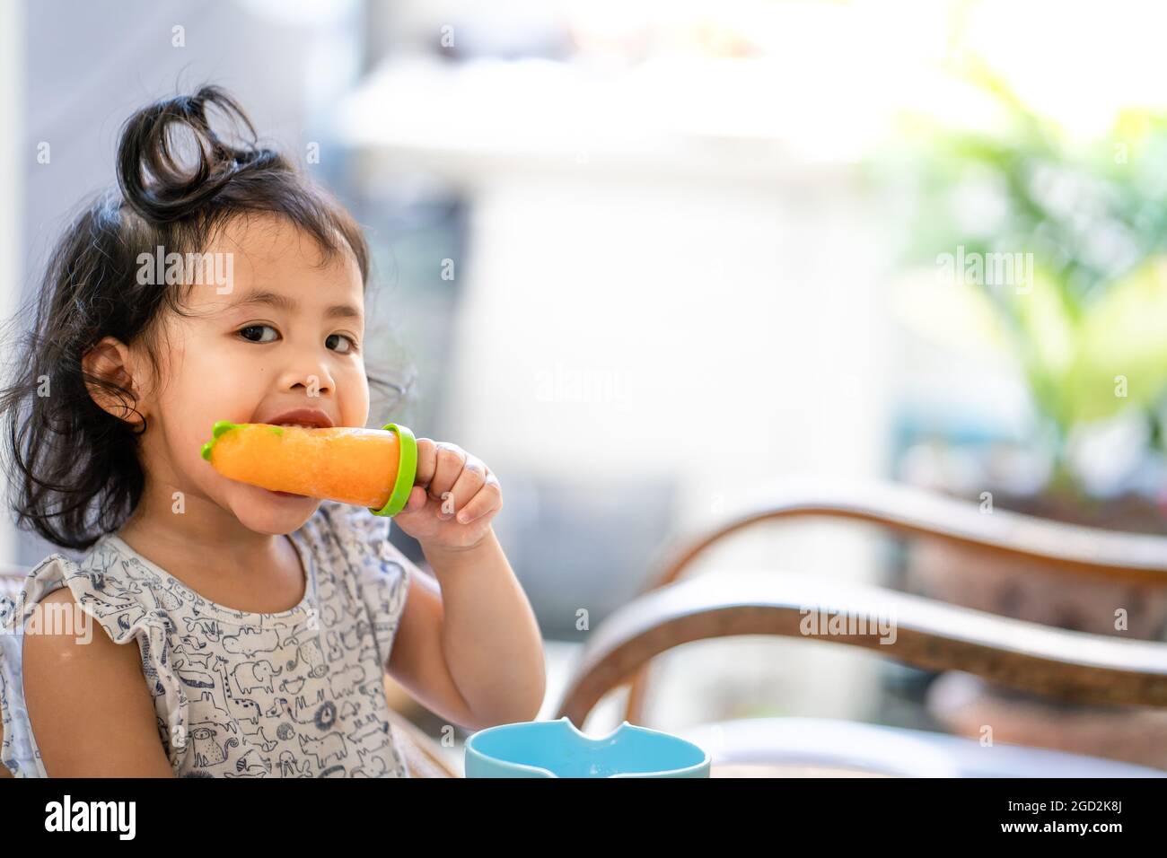 Small Asian female licking a popsicle Stock Photo - Alamy