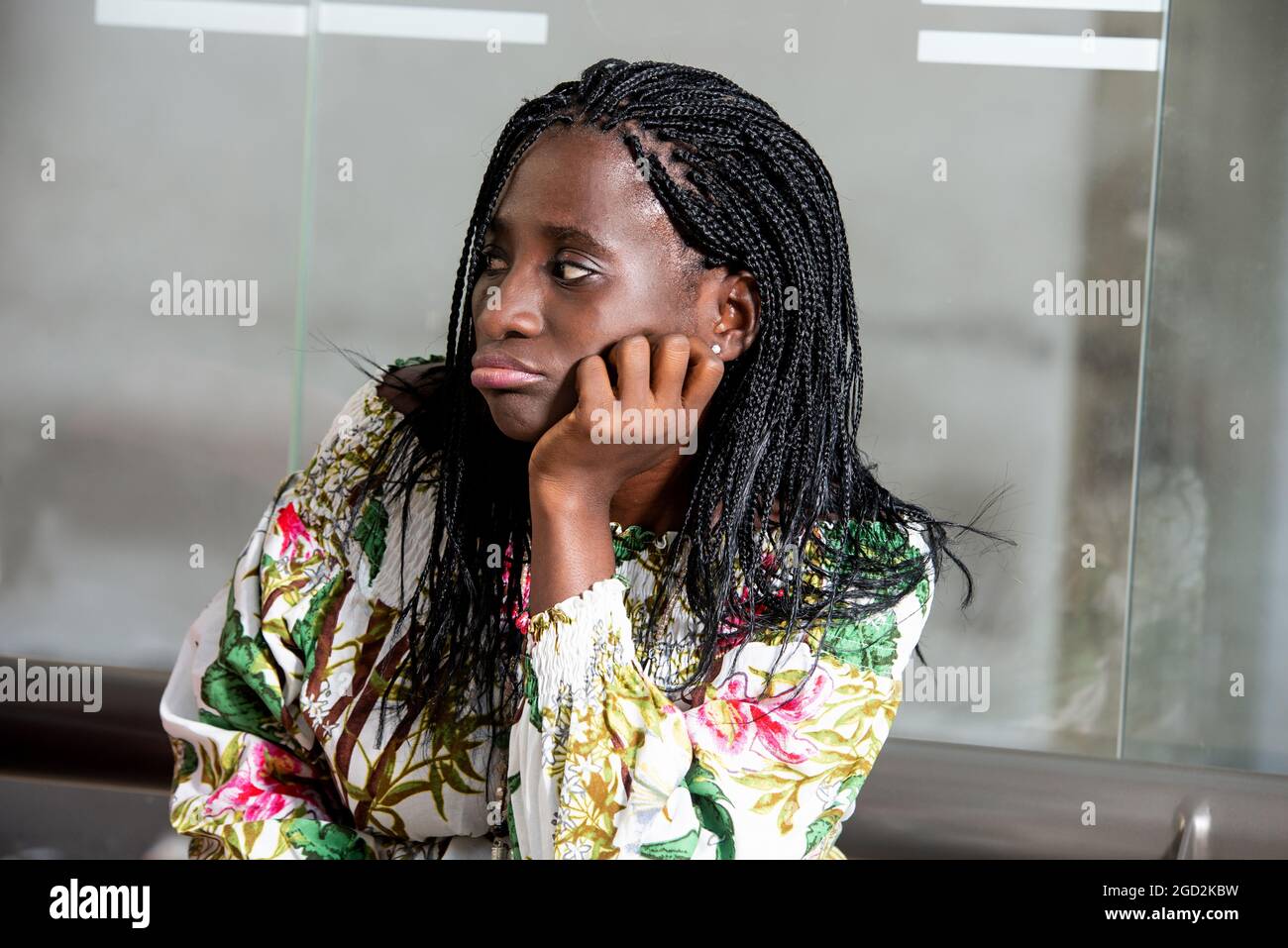 young woman sitting in a waiting room looking in profile with ...