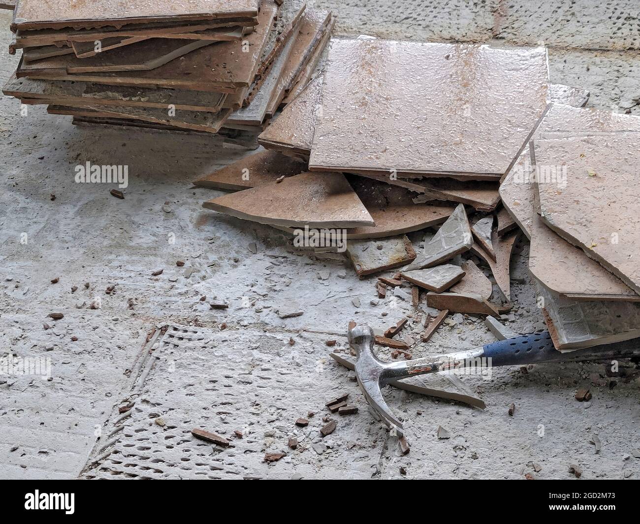 Hammer with broken ceramic floor tile on concrete Stock Photo - Alamy