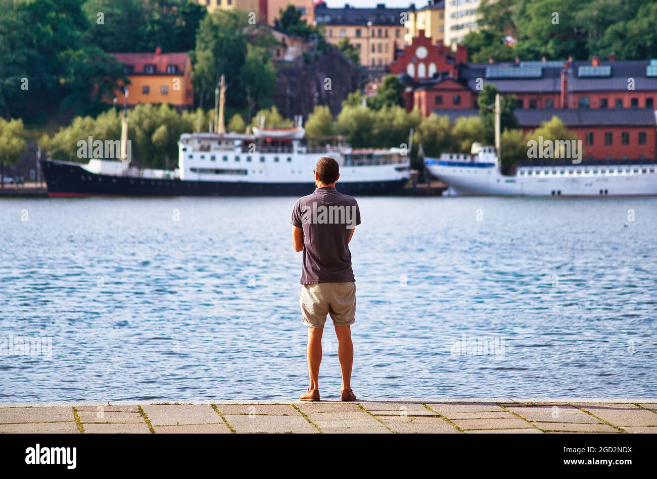 View of a male enjoying a breathtaking view of river, boats, and a ...