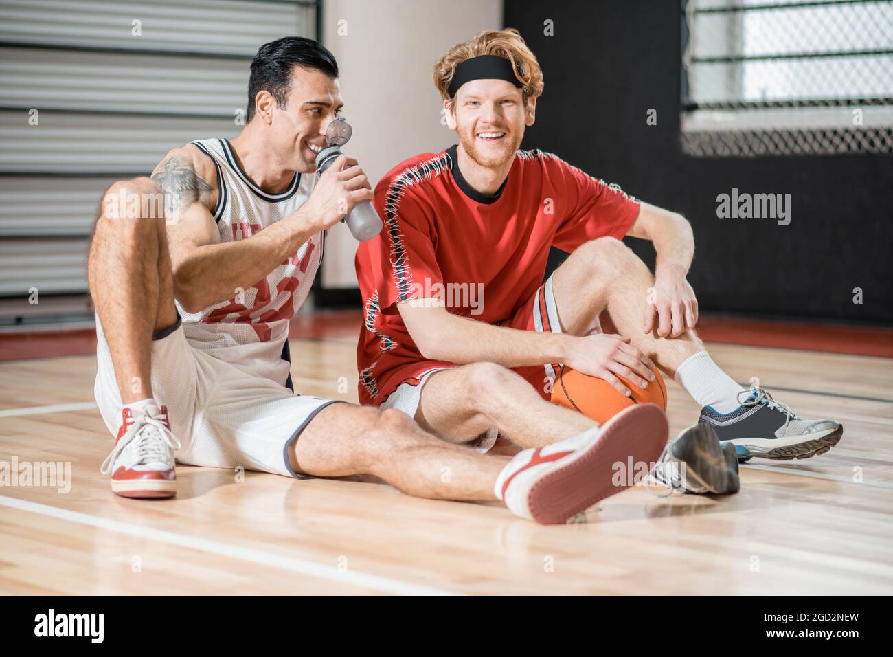 Two young men resting after the basketball game and talking Stock Photo ...