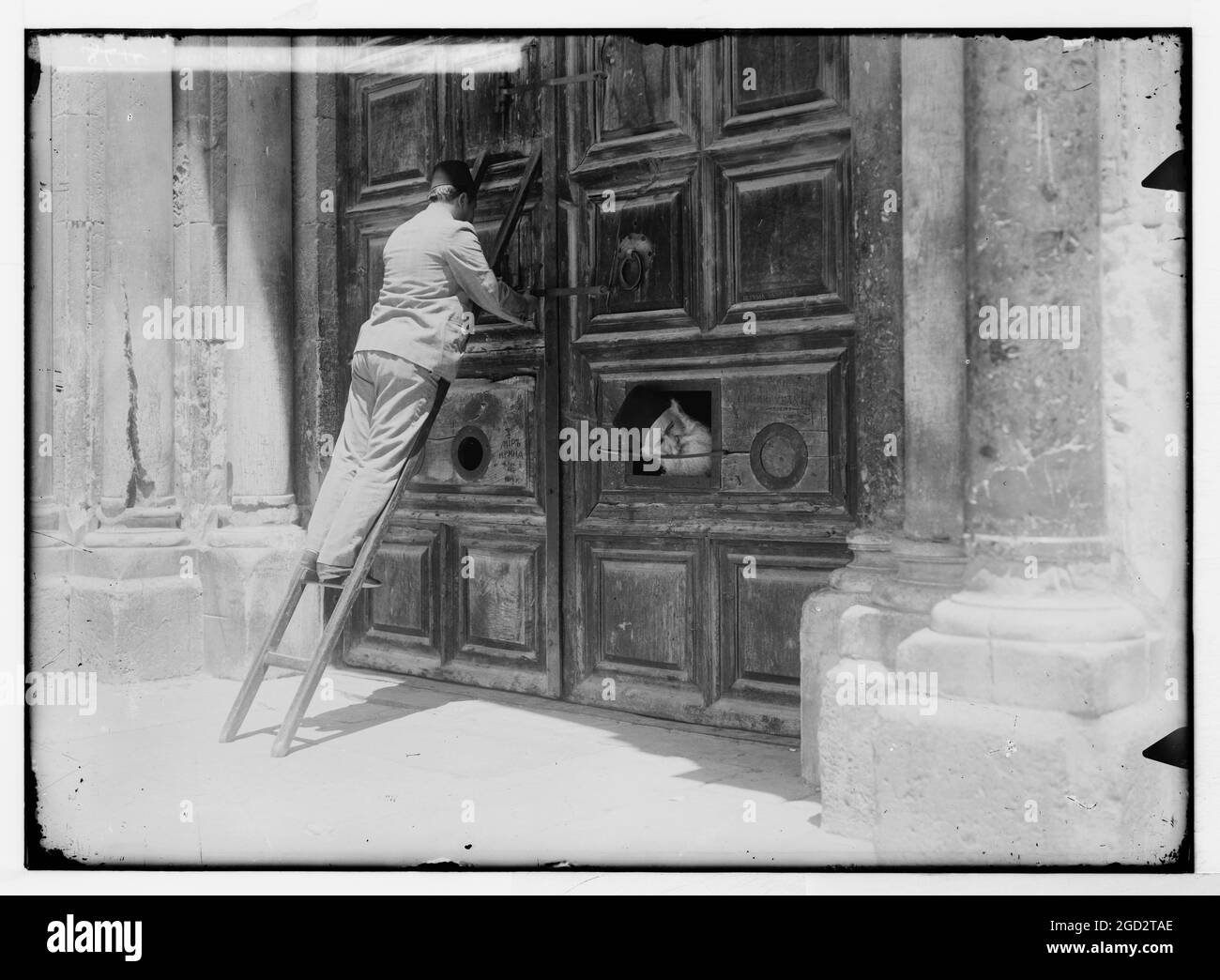 A man on a ladder is locking the locking the Church of the Holy ...