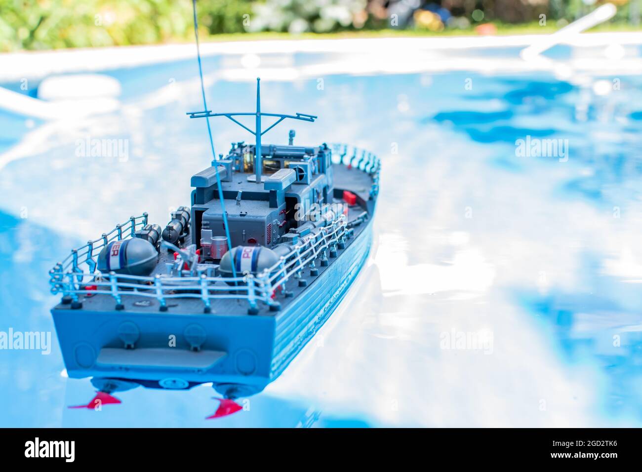 Toy battle ship floating on clear water in a pool in summer in Buenos ...