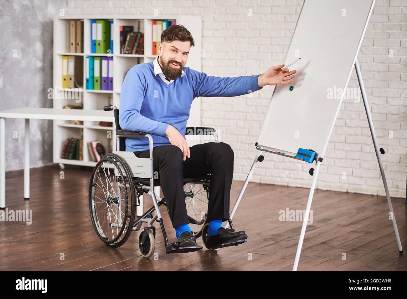 Disabled team leader using a board to draw chart and explaining Stock ...