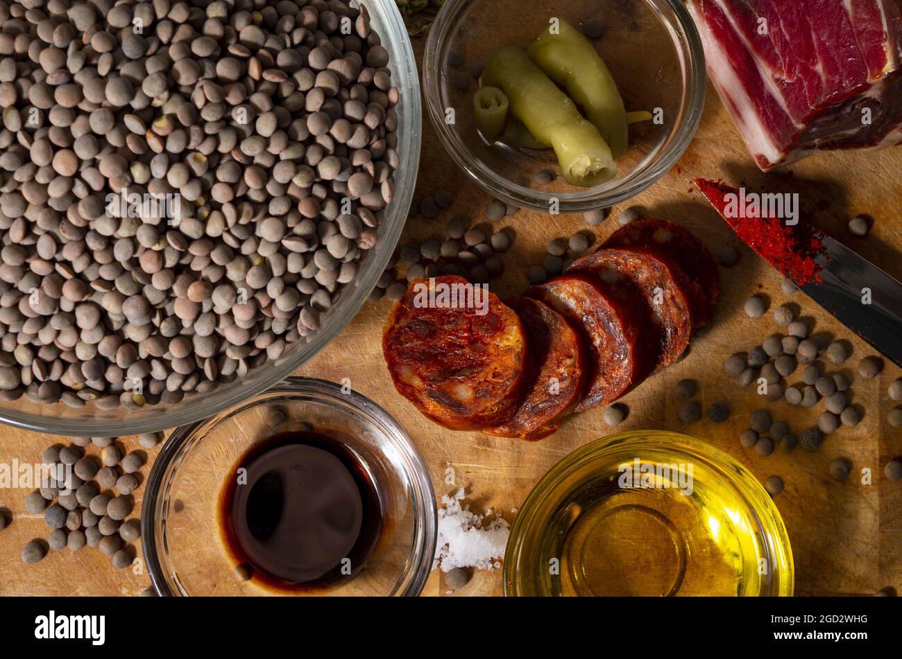 High angle shot of a bowl of lentils, oil, and some ingredients on a ...