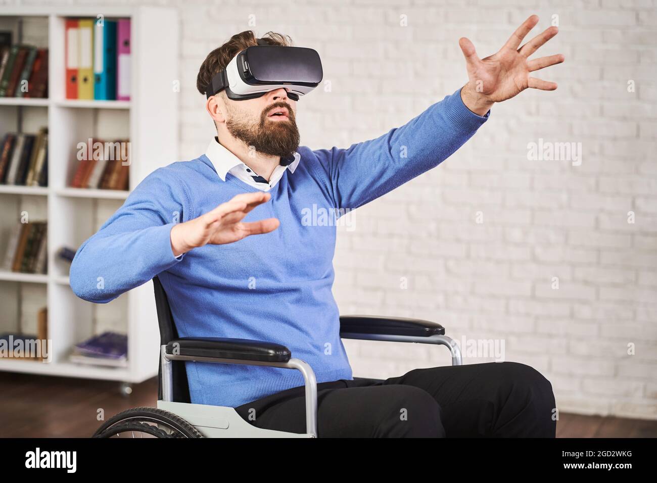 Portrait of a disabled man sitting in a wheelchair and using a VR ...