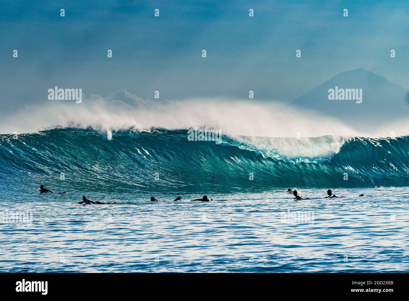 Big wave coming and many surfers waiting to catch it Stock Photo - Alamy