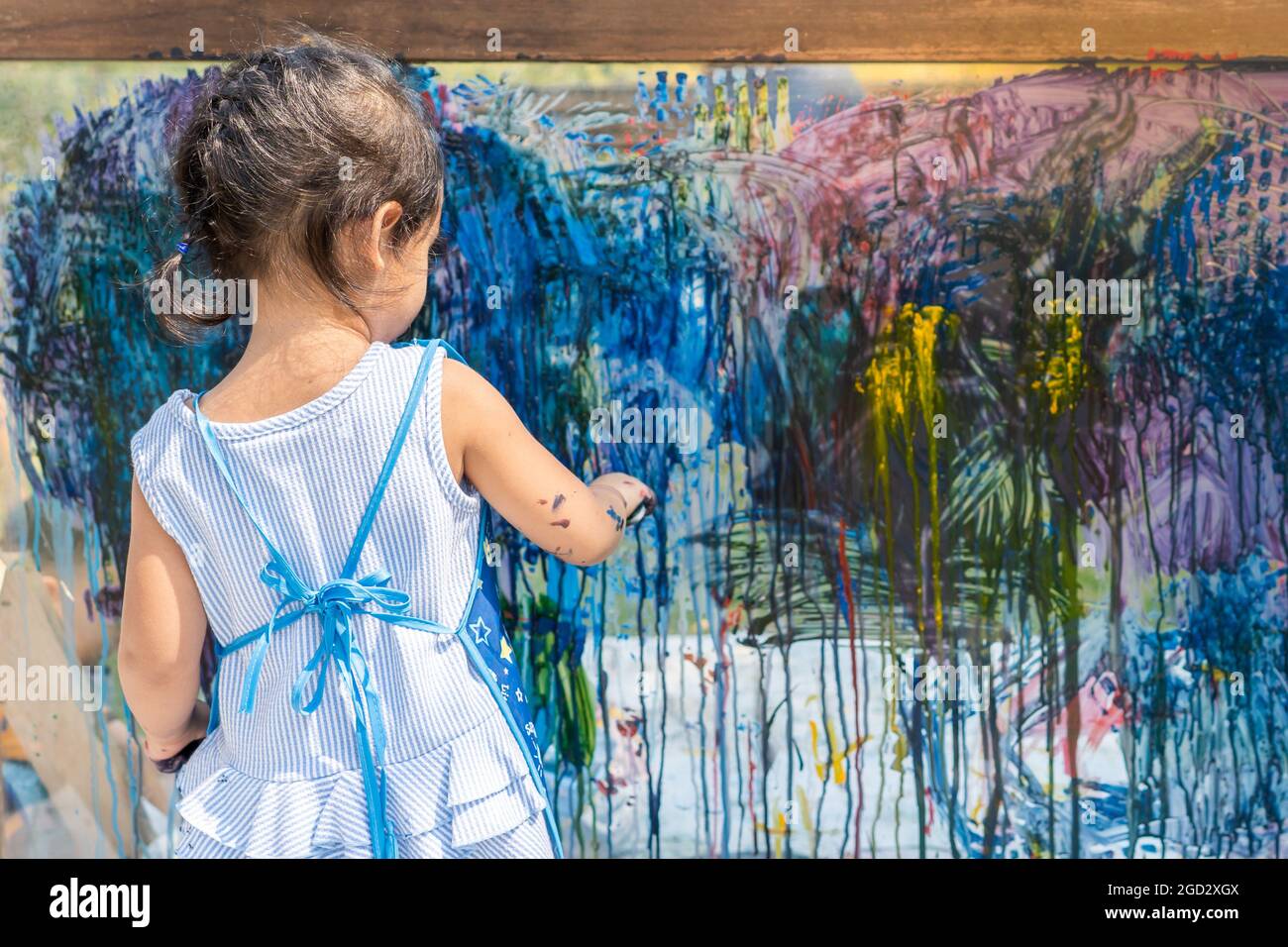 Cute little Thai girl painting on a glass Stock Photo - Alamy