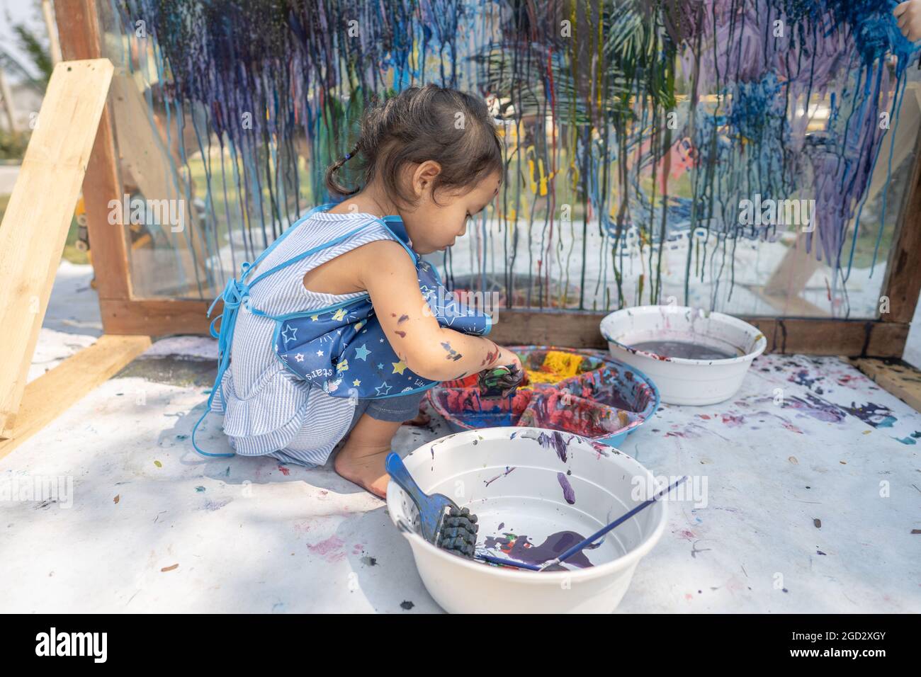 Cute little Thai girl painting on a glass Stock Photo - Alamy