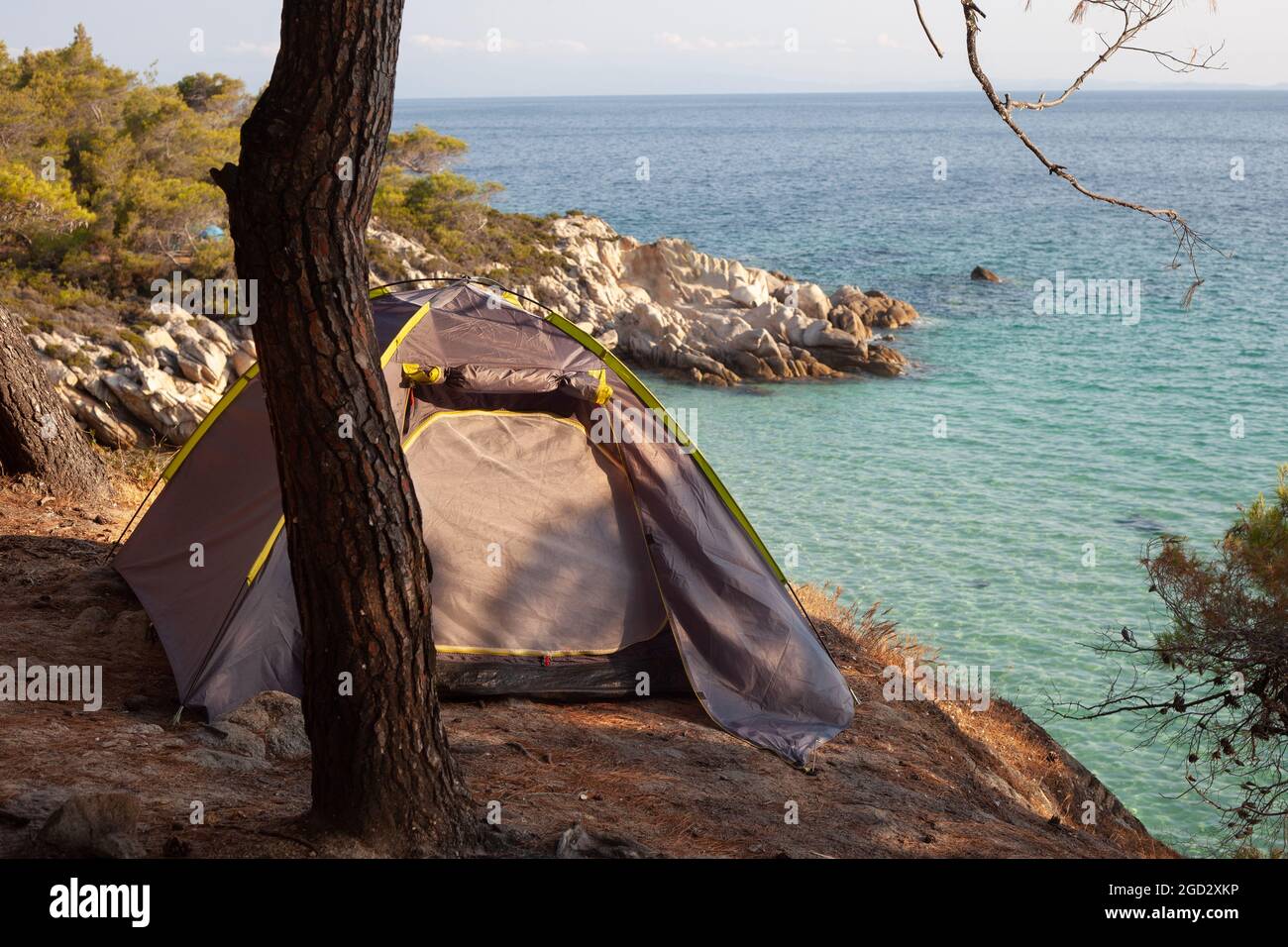 Camping grey tent on the edge of a cliff above the sea. Camping concept ...