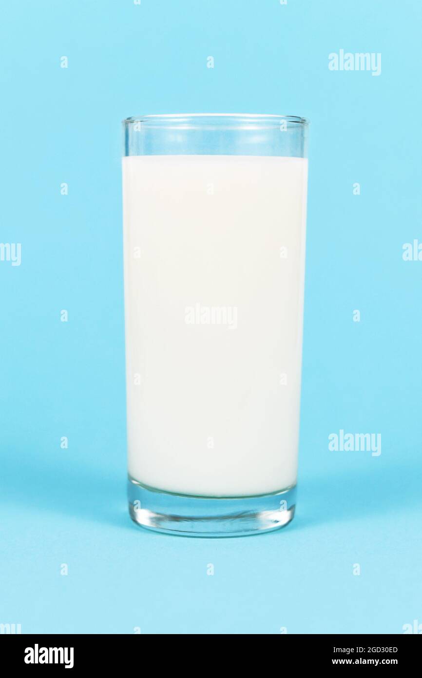 Glass of milk on blue background Stock Photo - Alamy