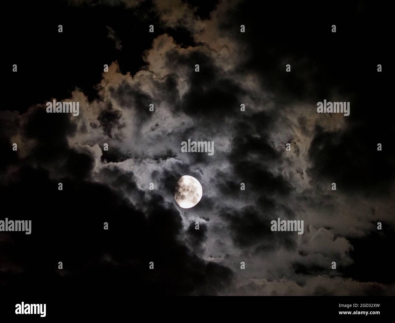 moon light behind dark clouds in stormy weather Stock Photo - Alamy