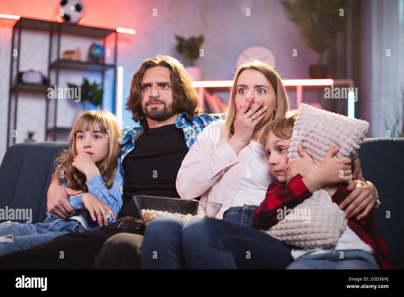 Caucasian family getting frightened and shocked while watching horror ...