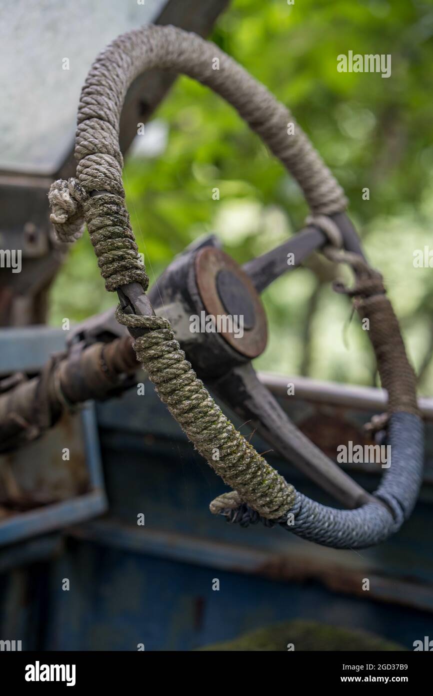 Vertical shot of a rope tied to an old metal steering wheel Stock Photo ...