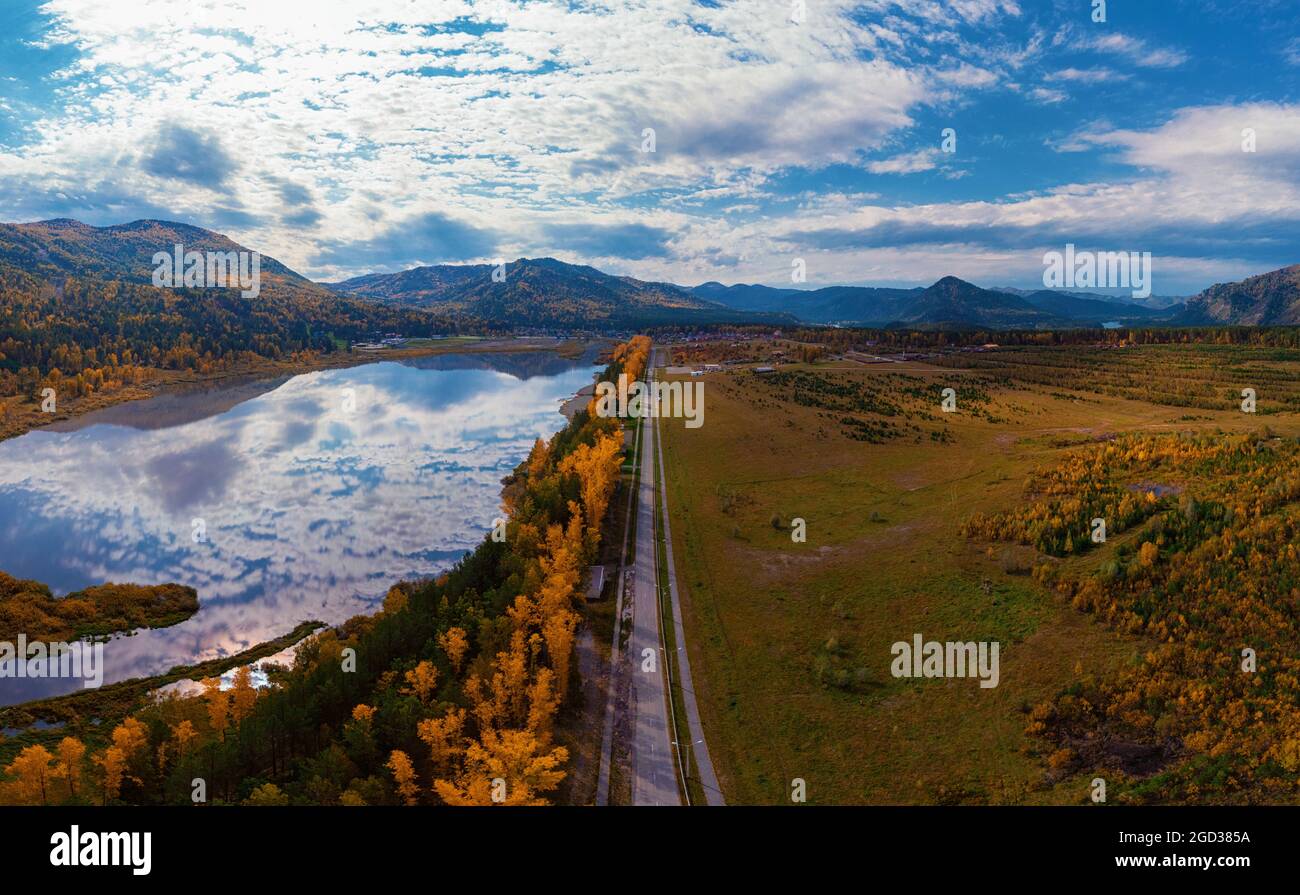 Aerial view of road and lake in beautiful autumn Altai forest ...