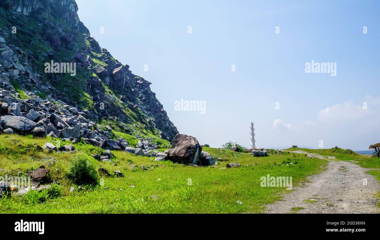 MARIVELES, PHILIPPINES - Jul 01, 2016: A road with a mountain and rocks ...