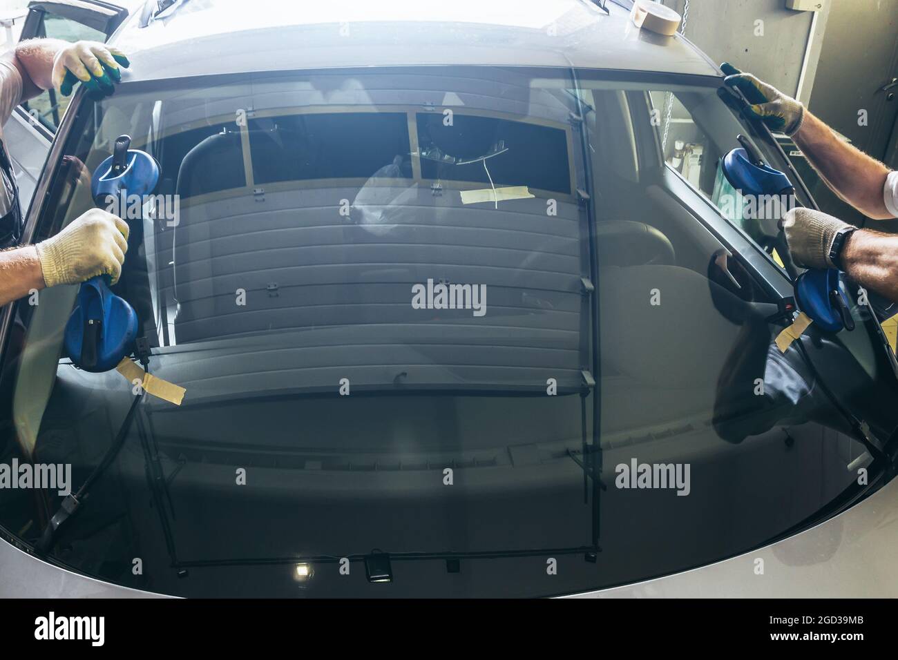 Mechanic workers hands changes broken windscreen on new windshield on ...