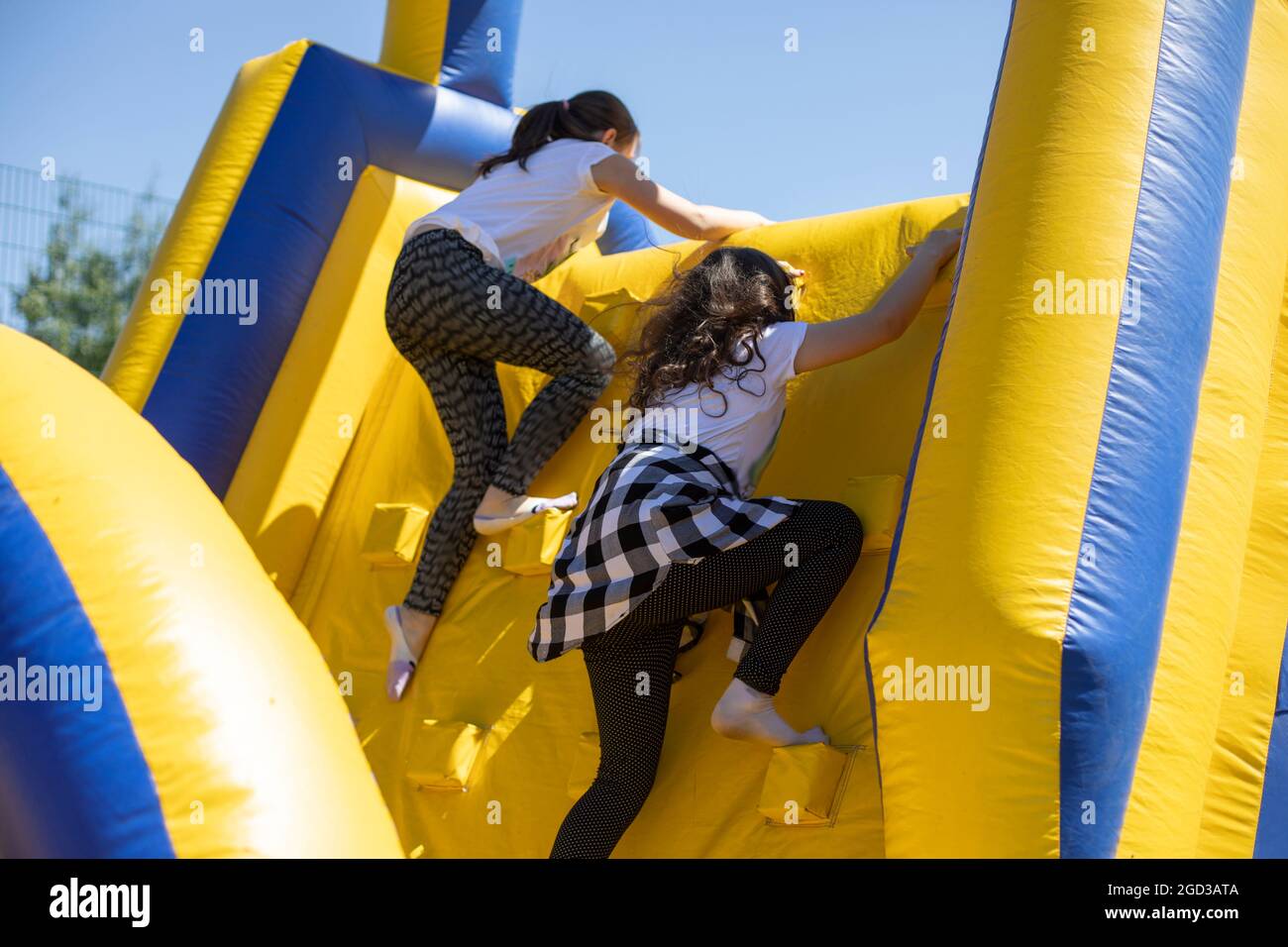 Children climb an inflatable slide. Inflatable obstacle course for fun ...