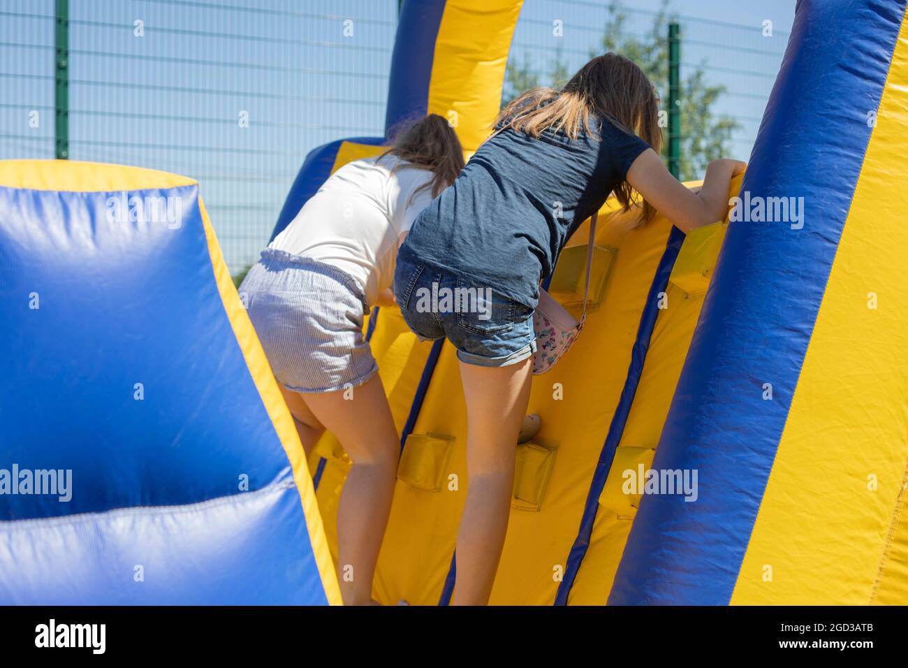 Children climb an inflatable slide. Inflatable obstacle course for fun ...