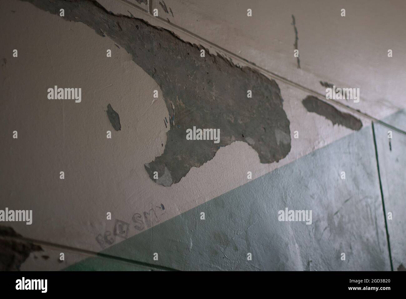 Wall with fallen paint. Wall at the entrance of a residential building ...