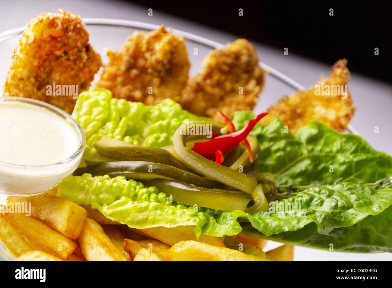 Fried chicken with french fries, lettuce and sauce in a bowl Stock ...