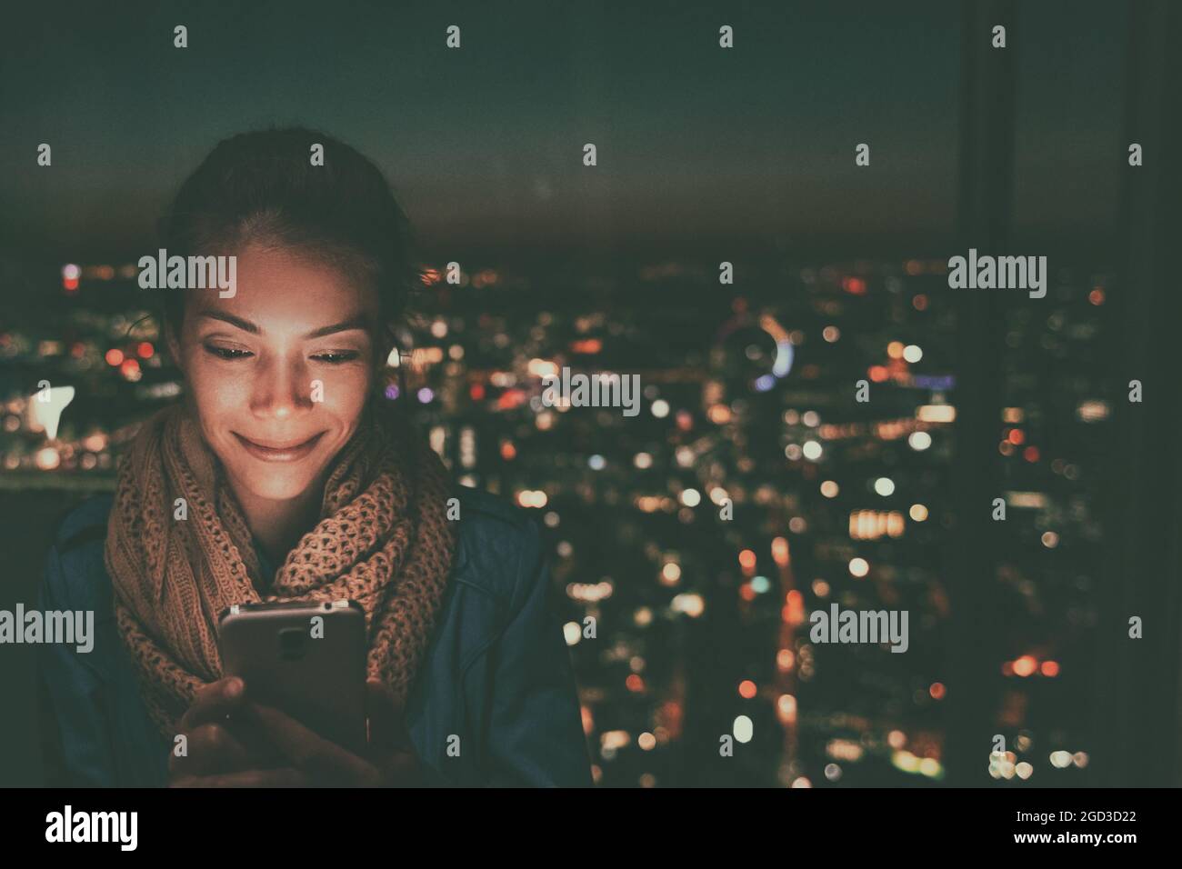 Phone Asian woman looking at bright screen of cellphone at night in ...