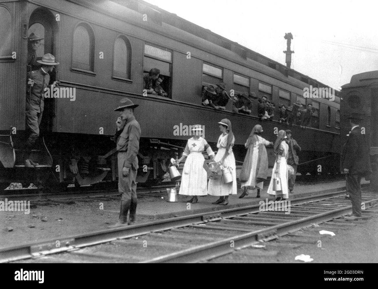 Men on troops train, with Red Cross workers in front, probably in ...