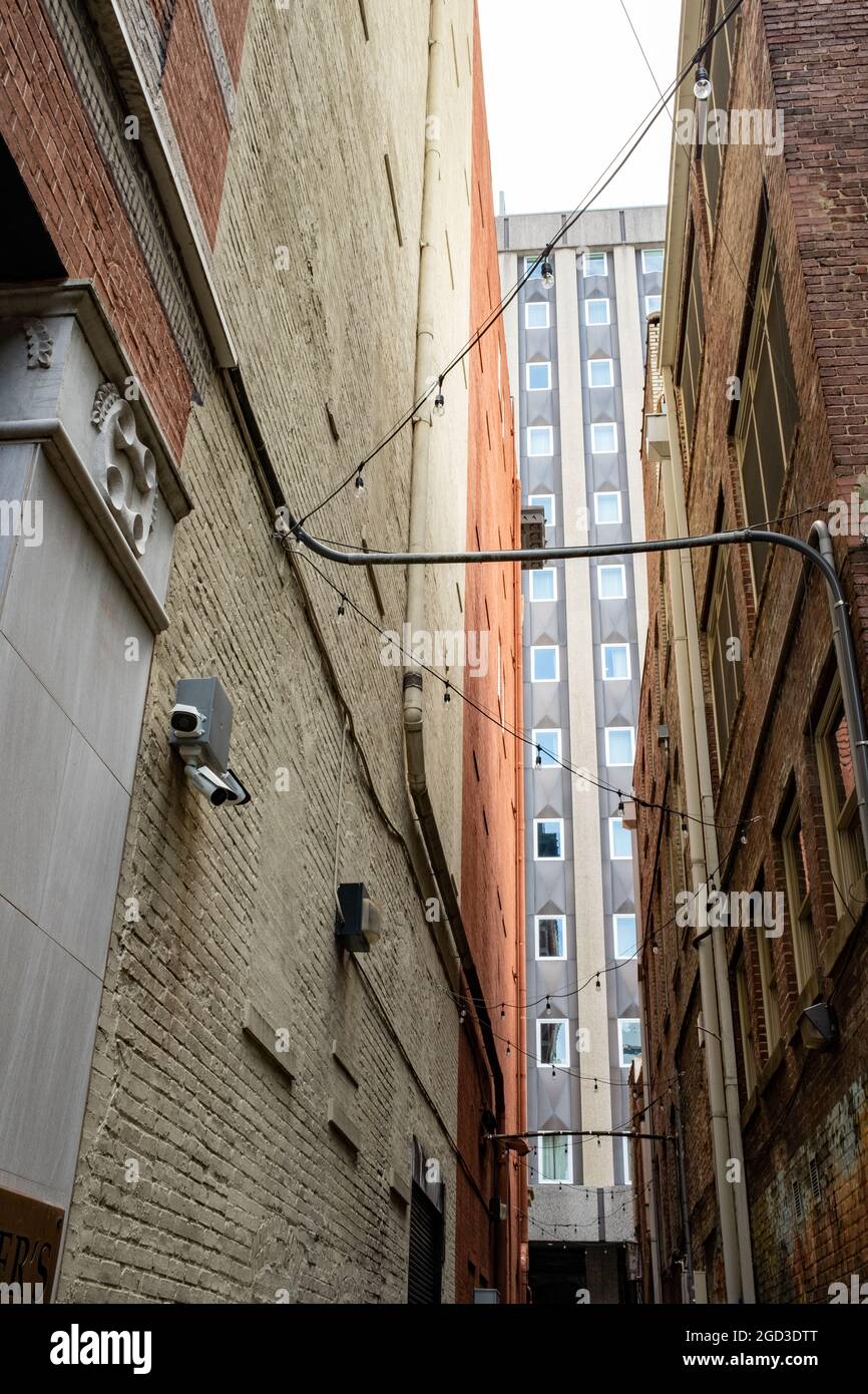 View of a new building emerging through an alleyway Stock Photo - Alamy