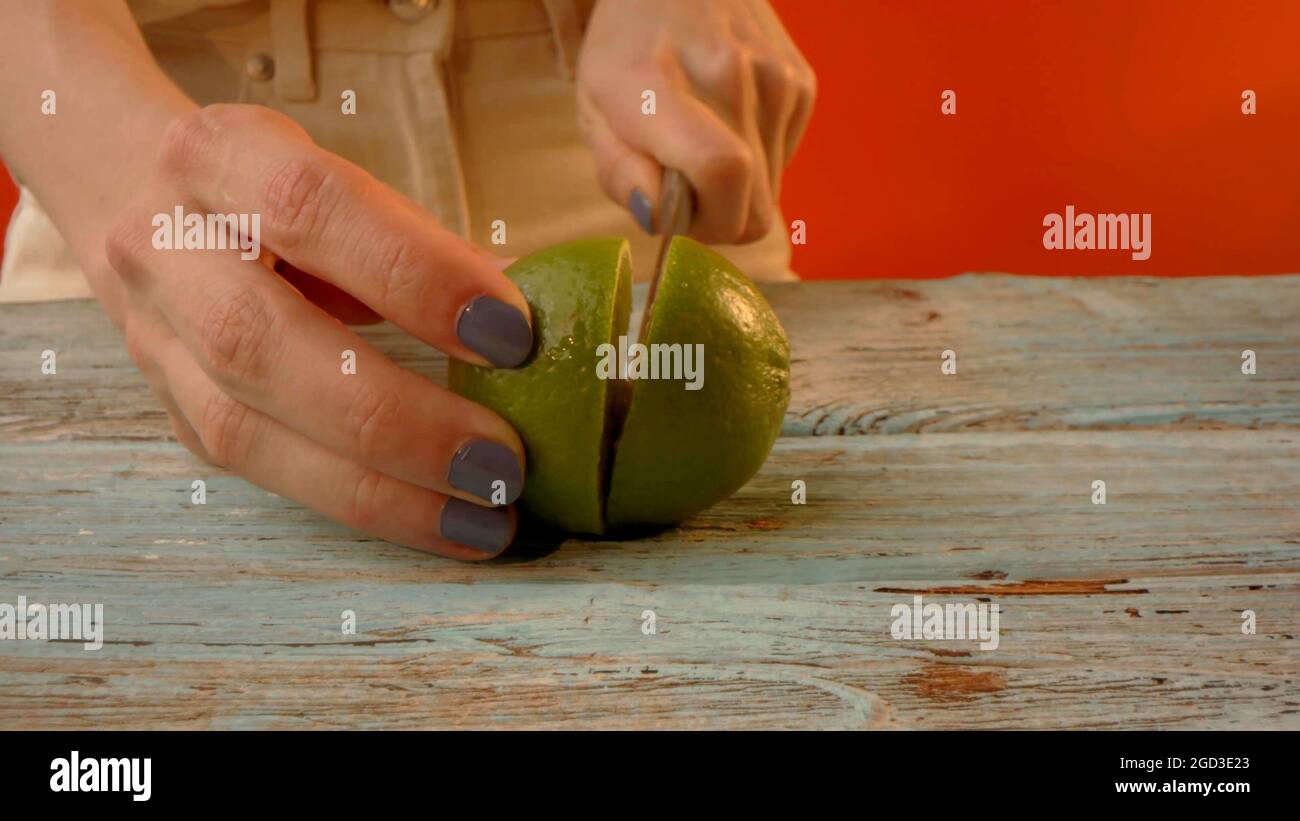 Hands is cutting a lime Stock Photo - Alamy