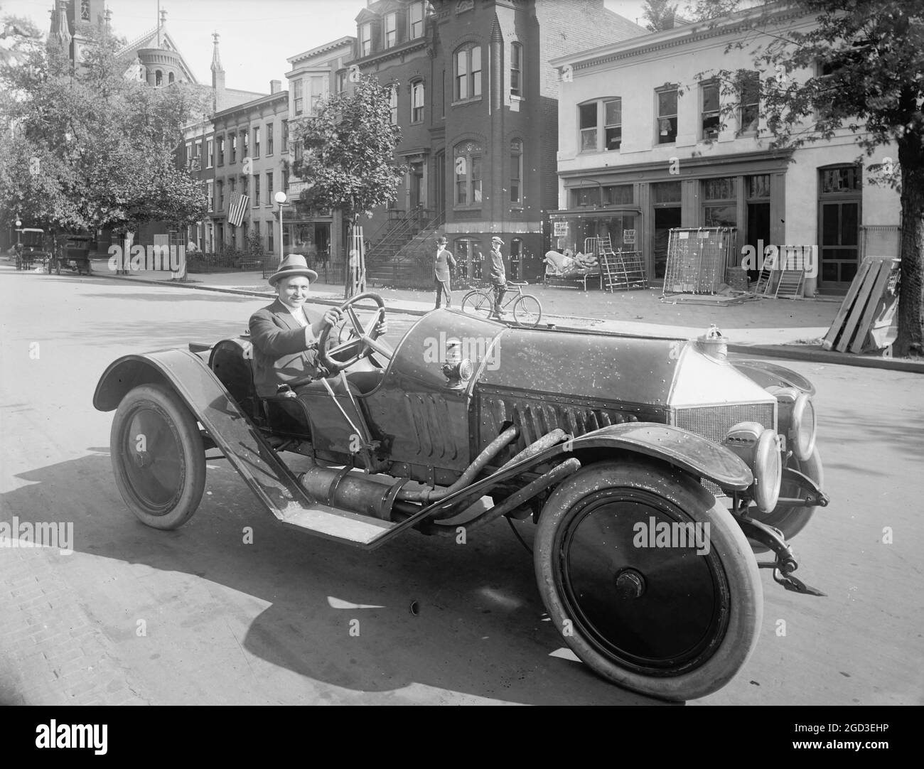 A man driving an early 20th century roadster car ca. between 1910 and ...