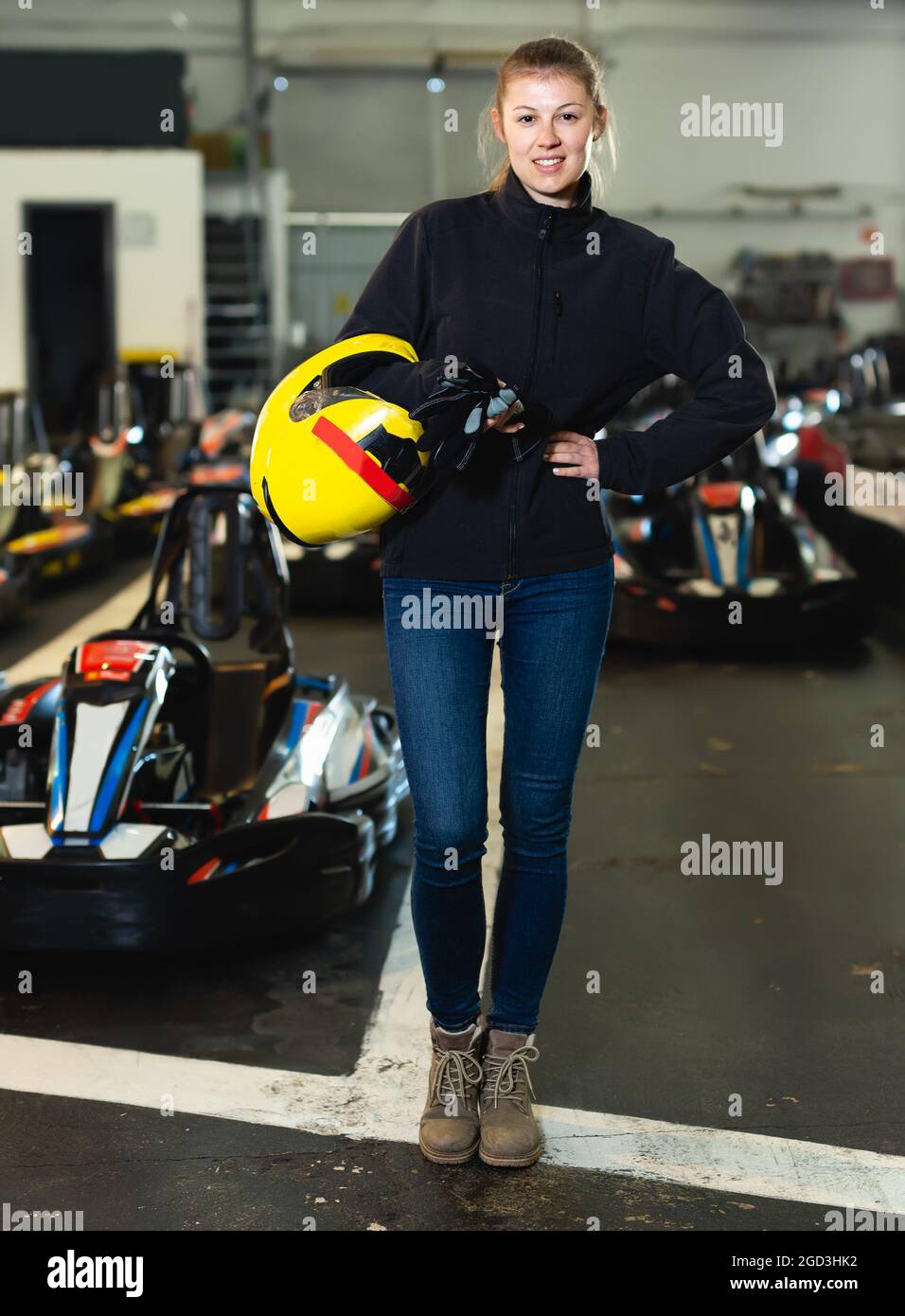 Fine woman with helmet standing near cars Stock Photo - Alamy
