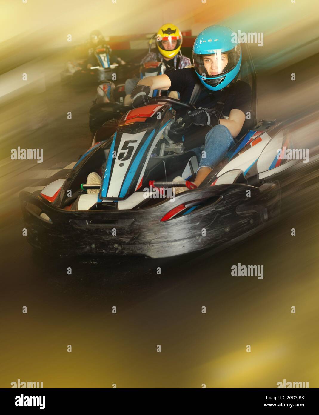 Man and women competing on racing cars Stock Photo - Alamy