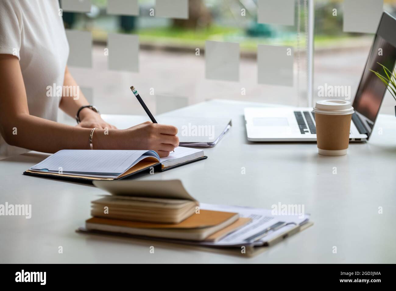 Close up asian female is taking notes on her notebook for online ...