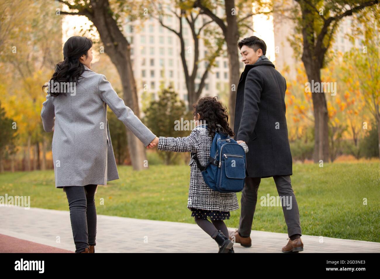 Parents taking child to school Stock Photo - Alamy