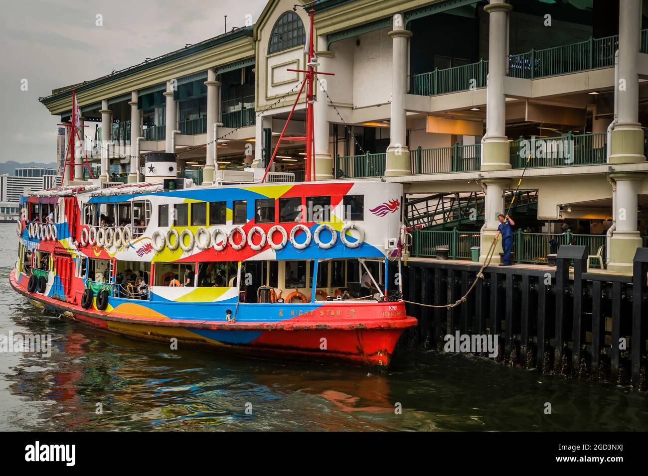 A crewman uses a boathook to retrieve the mooring rope of the 'Night ...
