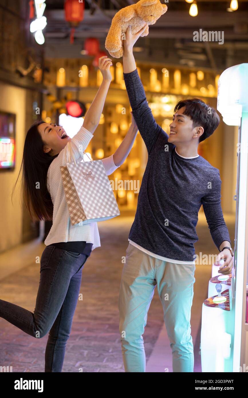 Happy young couple playing toy grabbing game Stock Photo - Alamy
